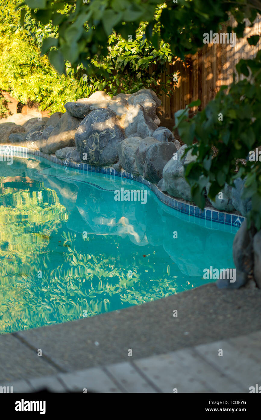 Rock landscape waterfall on swimming pool edge Stock Photo - Alamy