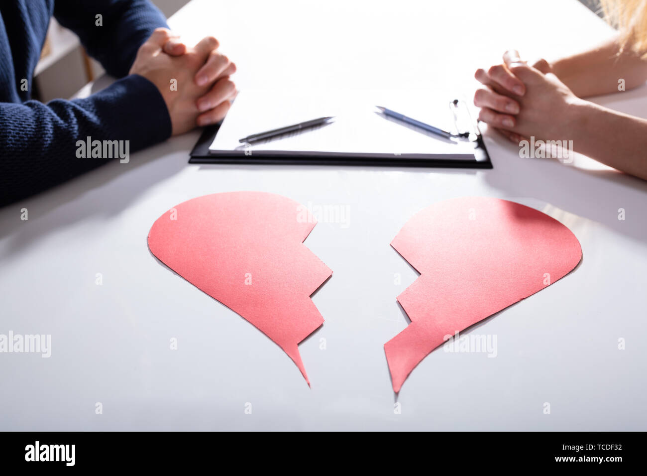 Couple's Hand With Divorce Paper And Broken Red Heart Over White Desk ...