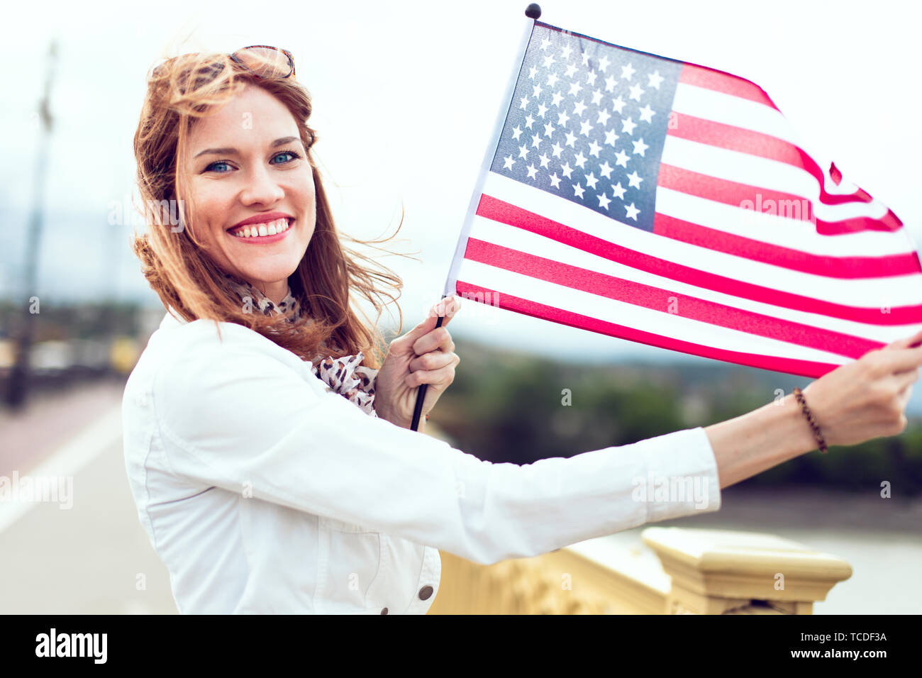 Happy young patriot urban woman with toothy smile stretching star ...