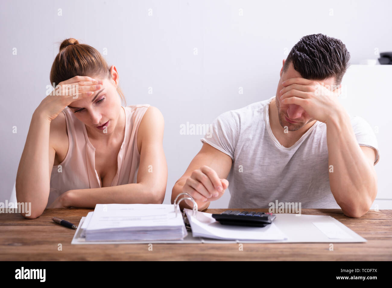 Stressed Young Couple Looking At Invoice On Wooden Desk Stock Photo - Alamy