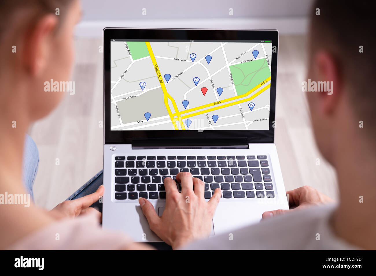 Rear View Of Couple Using GPS Map With Navigation Pointer On Laptop ...
