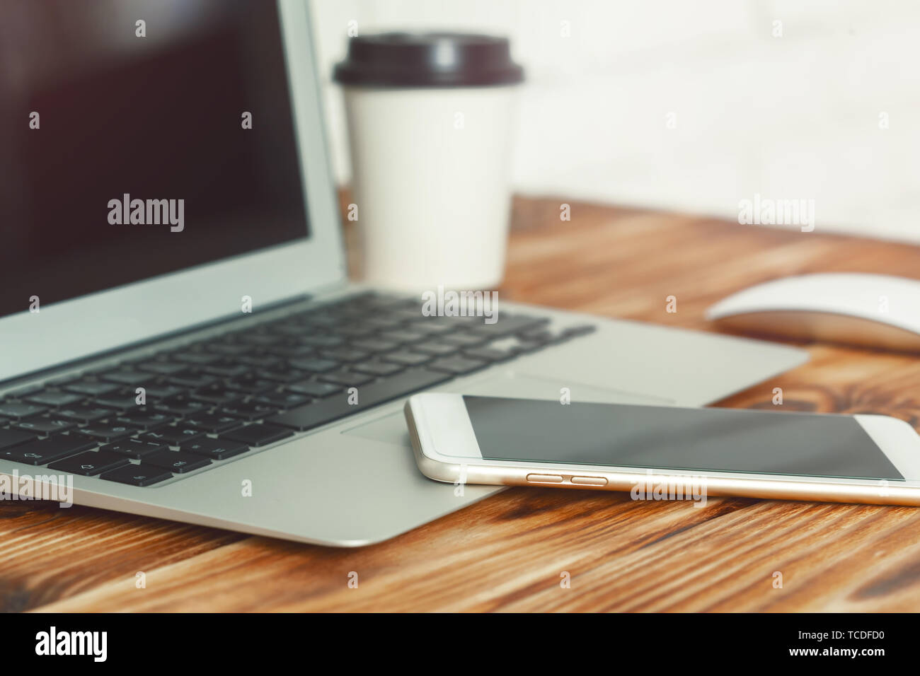 office desk with laptop smart phone and business office background ...