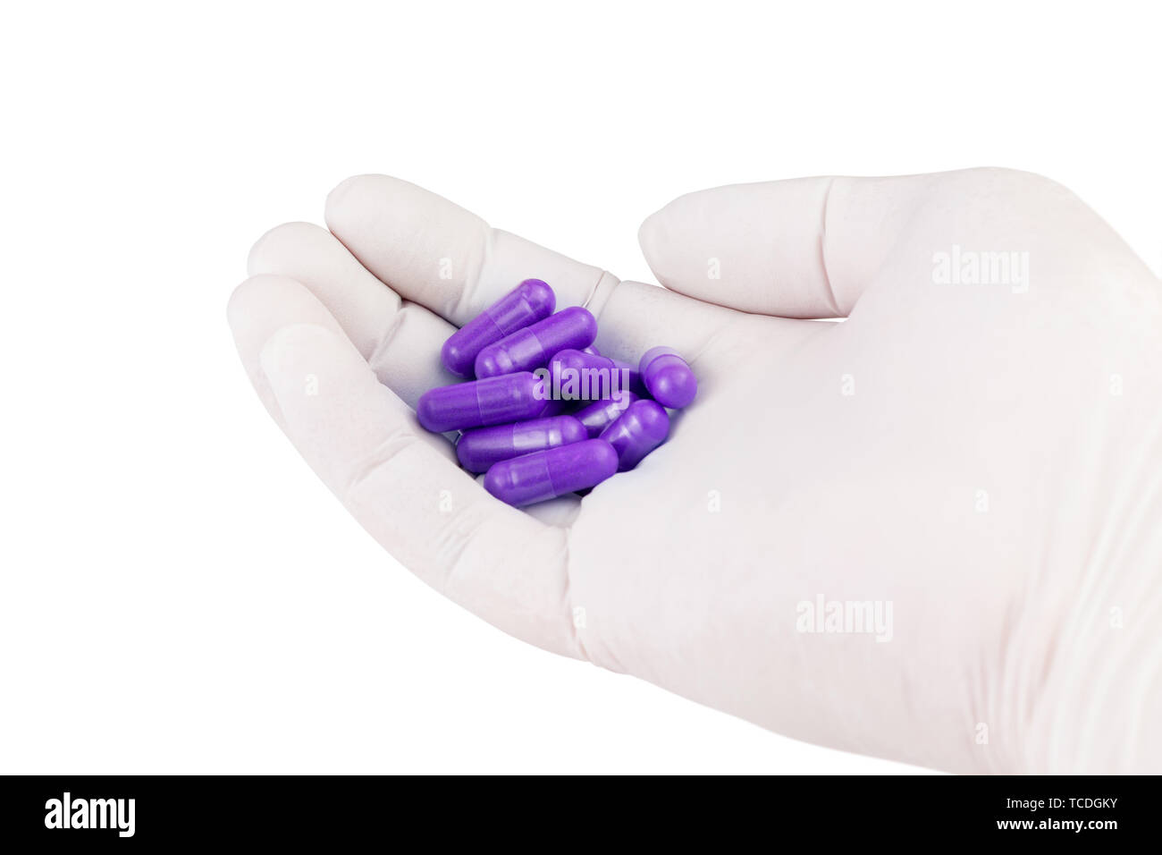 hand in medical glove holding proton purple color organic med capsules ...