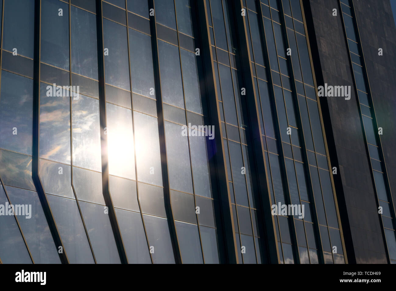 closeup of a modern window glass building with sun reflecting in it ...