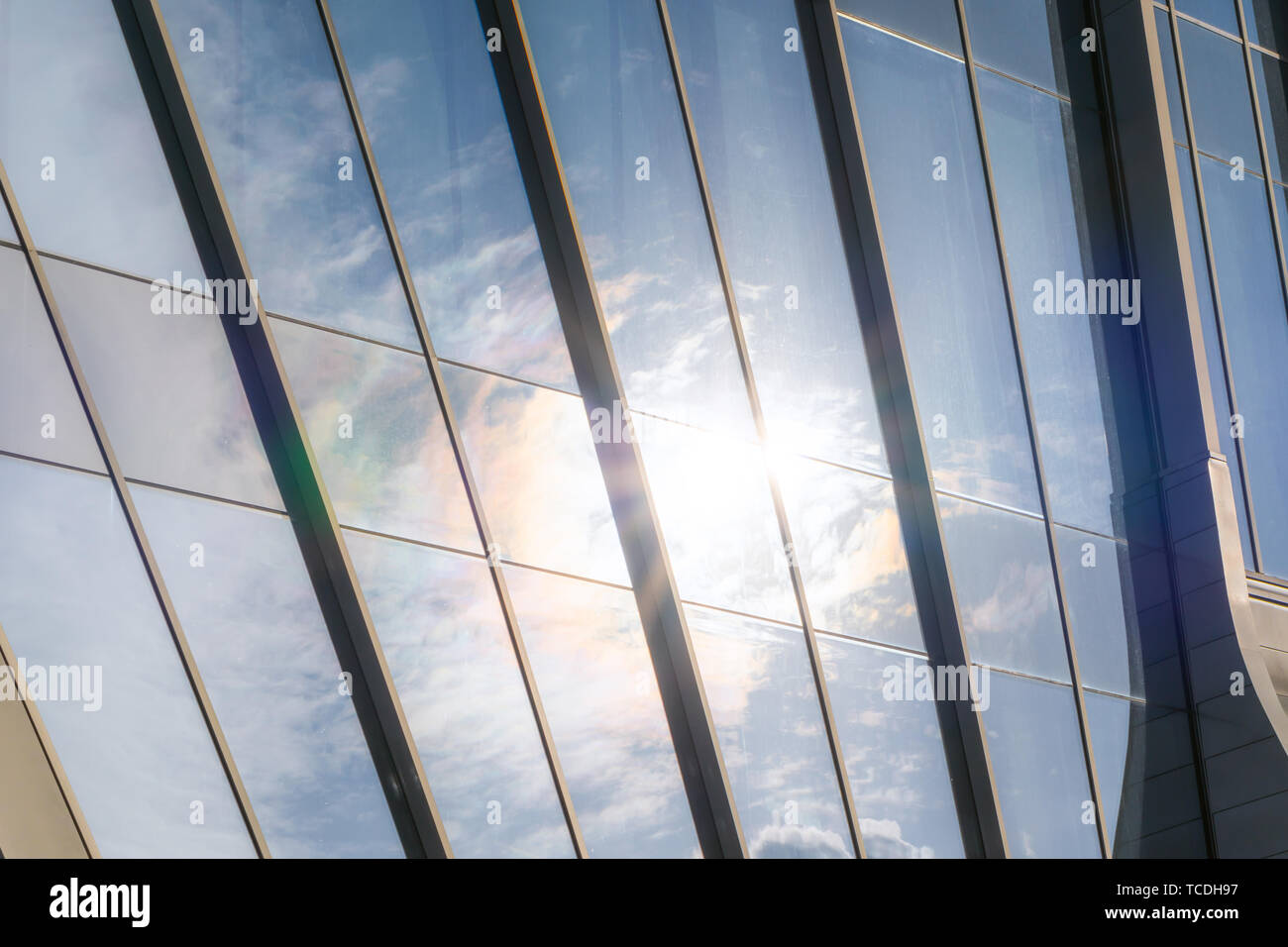 closeup of a modern window glass building with sun and blue sky ...