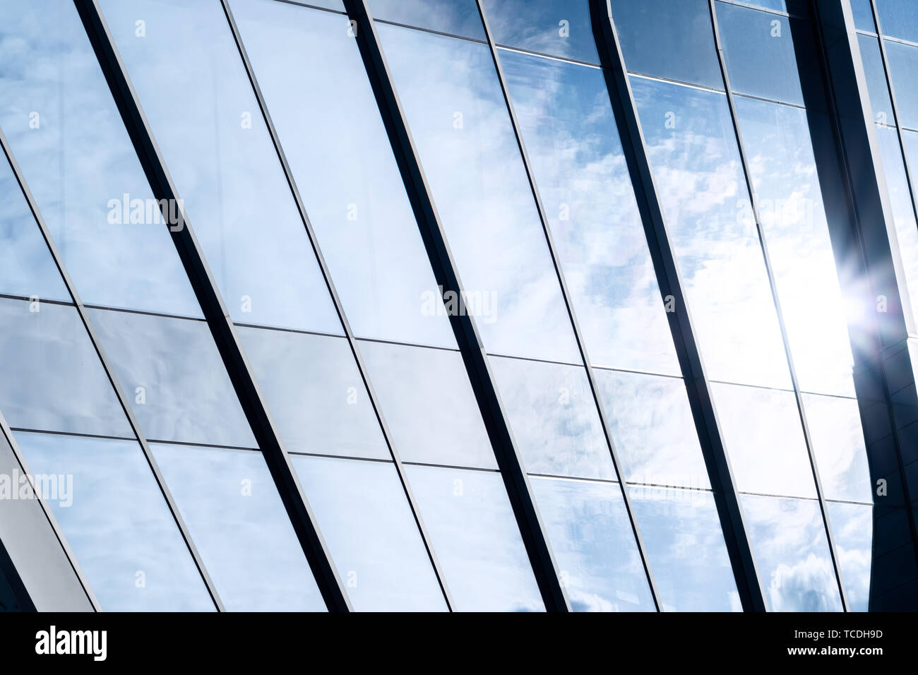 closeup of a modern window glass building with sun and blue sky ...