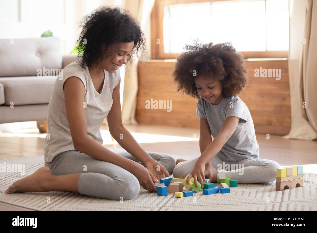 Cute little african kid playing with black mom on floor Stock Photo - Alamy