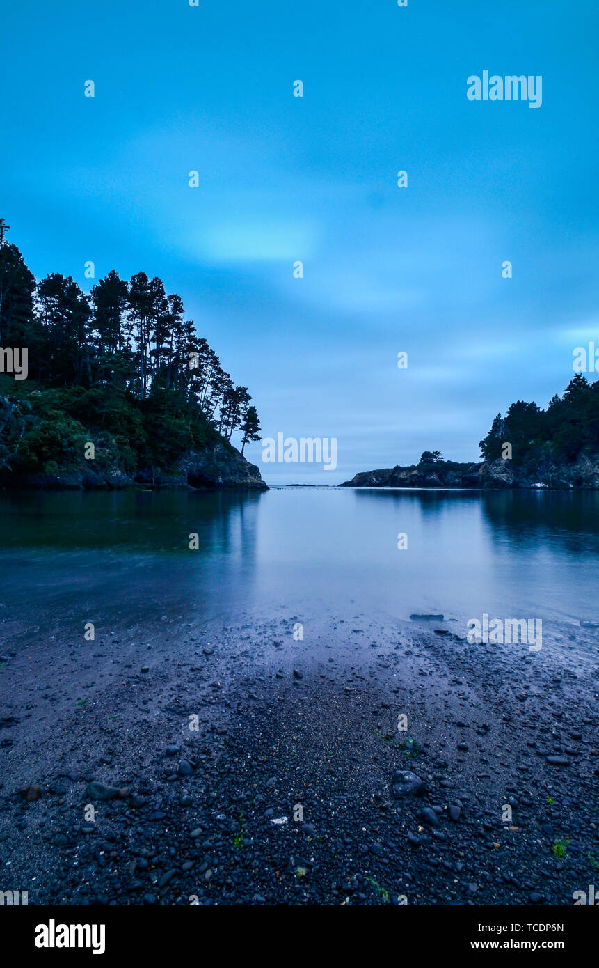 Rocks and sand revealed by a low tide at night Stock Photo - Alamy