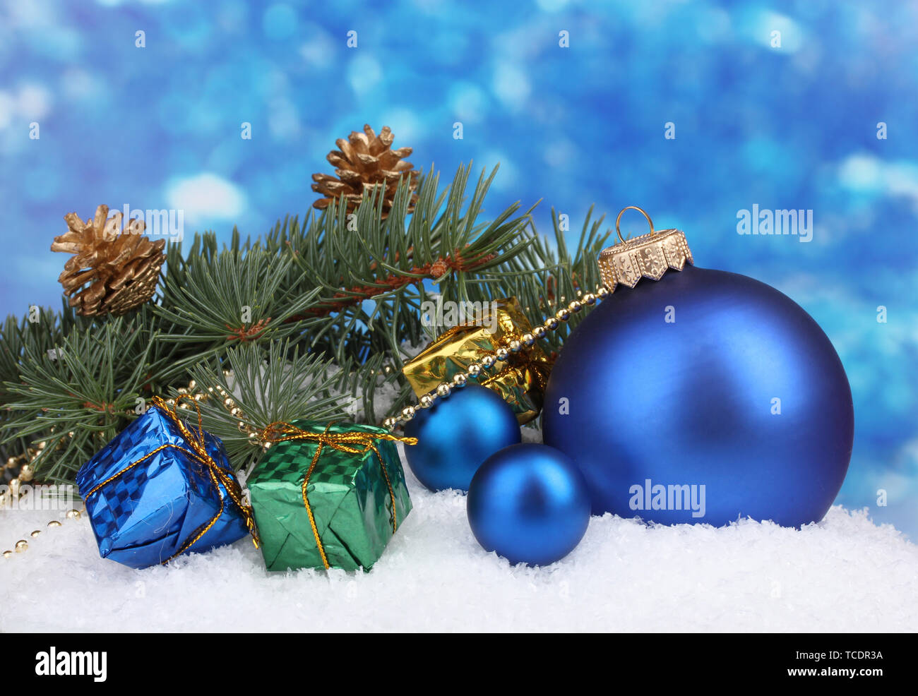 Christmas ball and green tree in the snow on blue Stock Photo - Alamy
