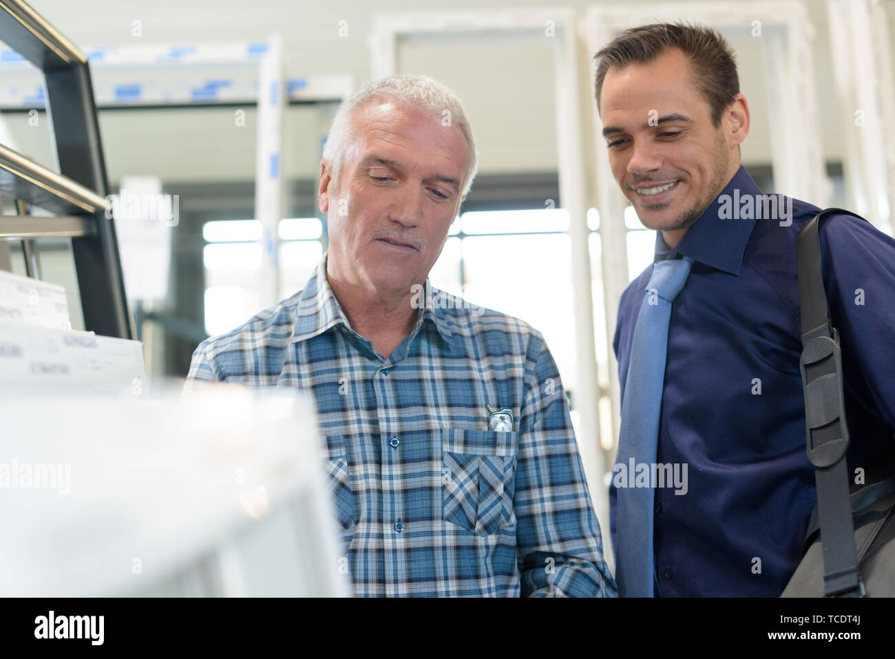 two people supervising windows in a workshop Stock Photo - Alamy