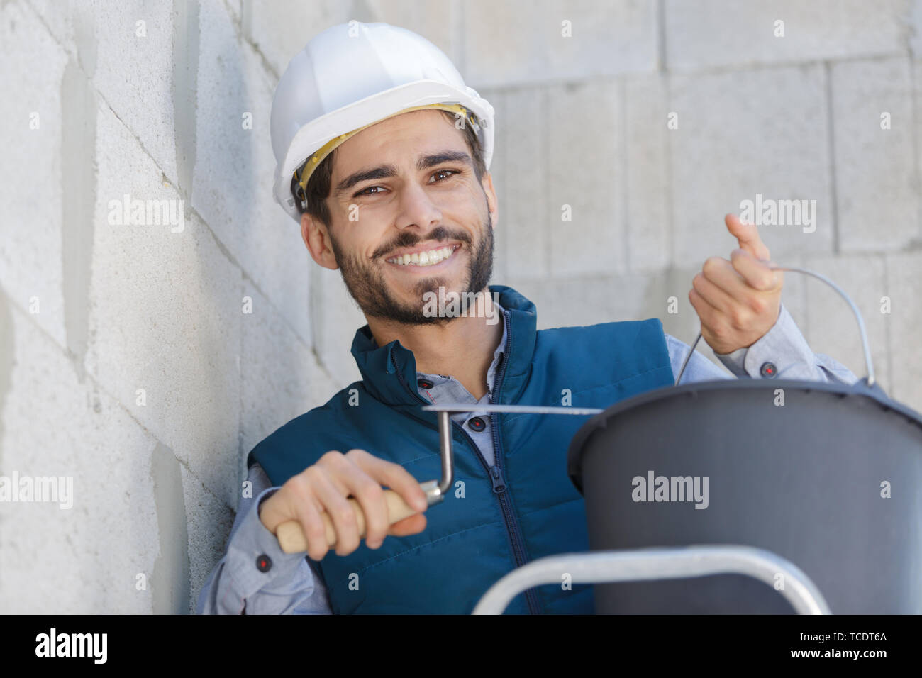 happy young man holding a trowel Stock Photo - Alamy