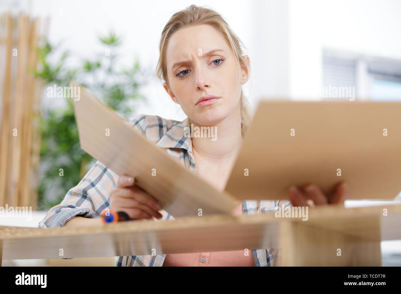 frustrated woman trying to fix something Stock Photo - Alamy