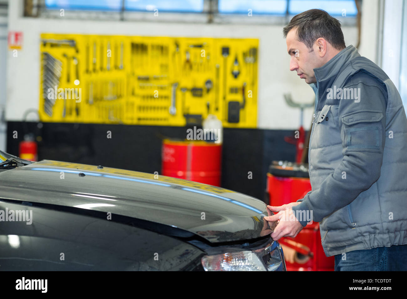 mechanic closing lid of car Stock Photo - Alamy