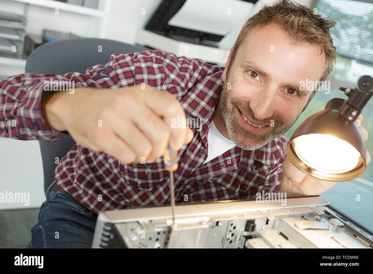 smiling man fixes a system unit of computer device Stock Photo - Alamy