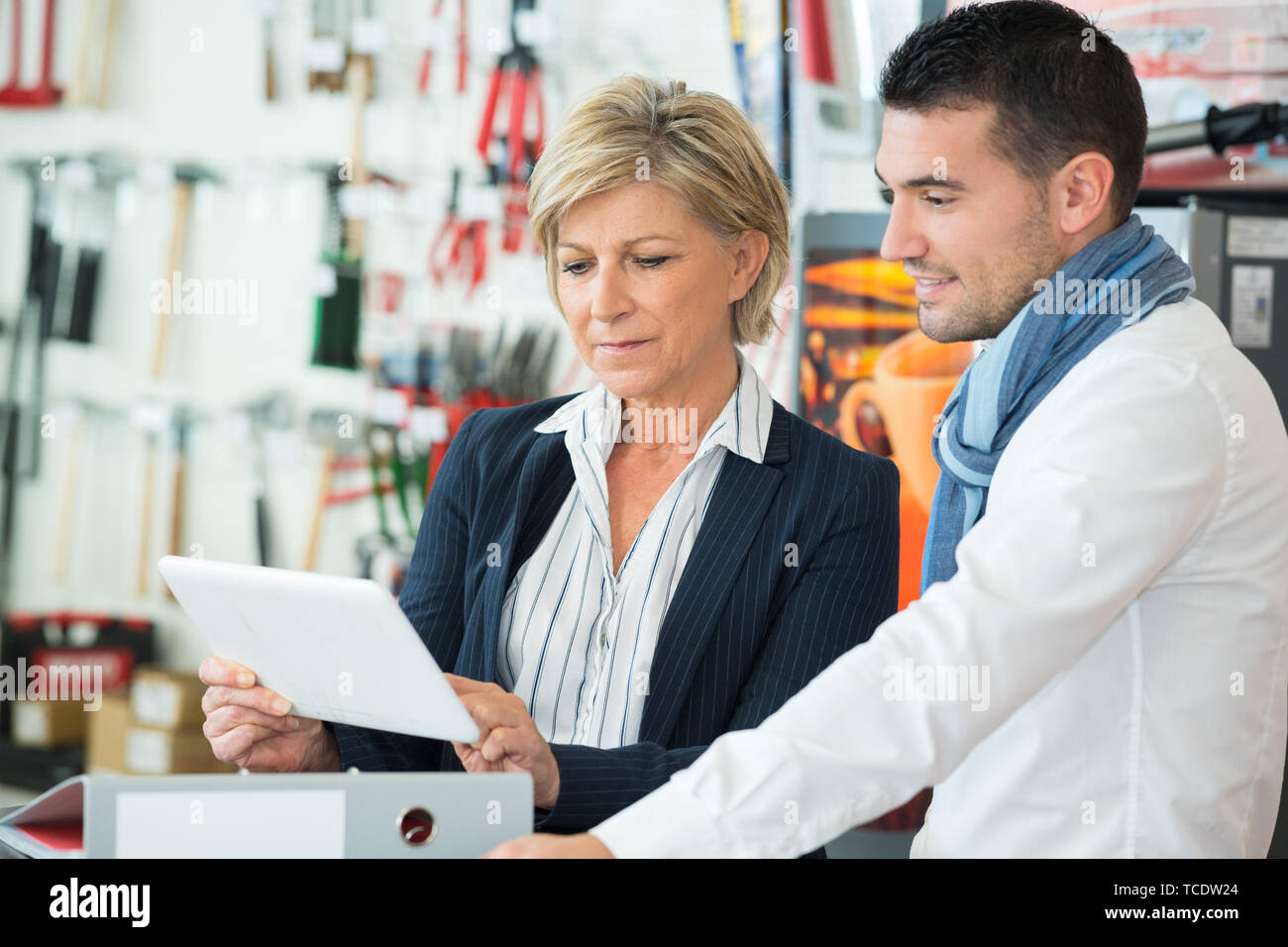 workers looking at tablet in hardware store Stock Photo - Alamy