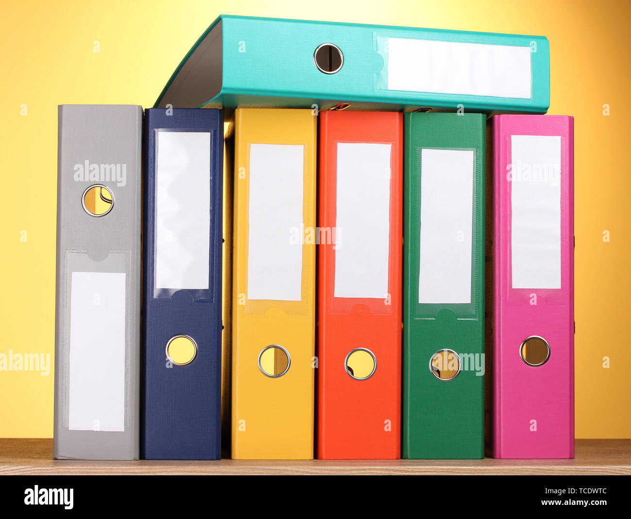 bright office folders on wooden table on yellow background Stock Photo ...