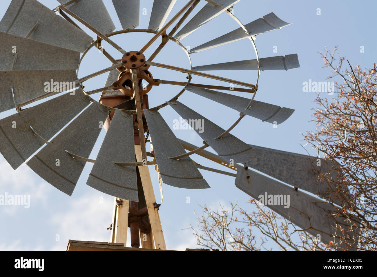 From below aged windmill with broken wings in blue sky Stock Photo - Alamy