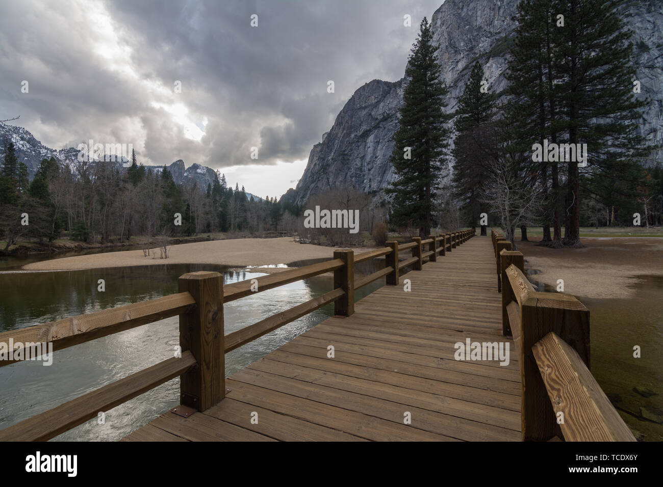 View of paved wooden walkway crossing shallow water in preserved area ...