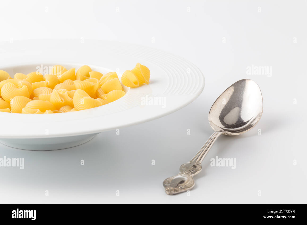 Italian pasta (Gomiti Rigati) on white background Stock Photo - Alamy