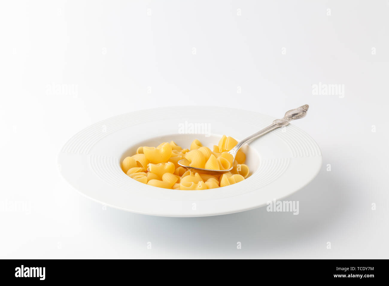 Italian pasta (Gomiti Rigati) on white background Stock Photo - Alamy