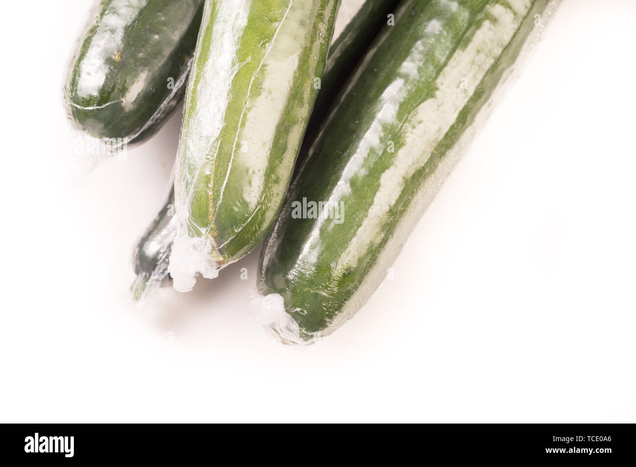 Bunch of cucumber wrapped in plastic films, isolated on white ...