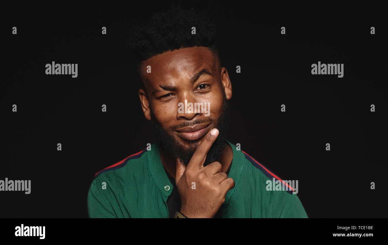 Portrait of happy african male looking at camera with a raised eyebrow ...