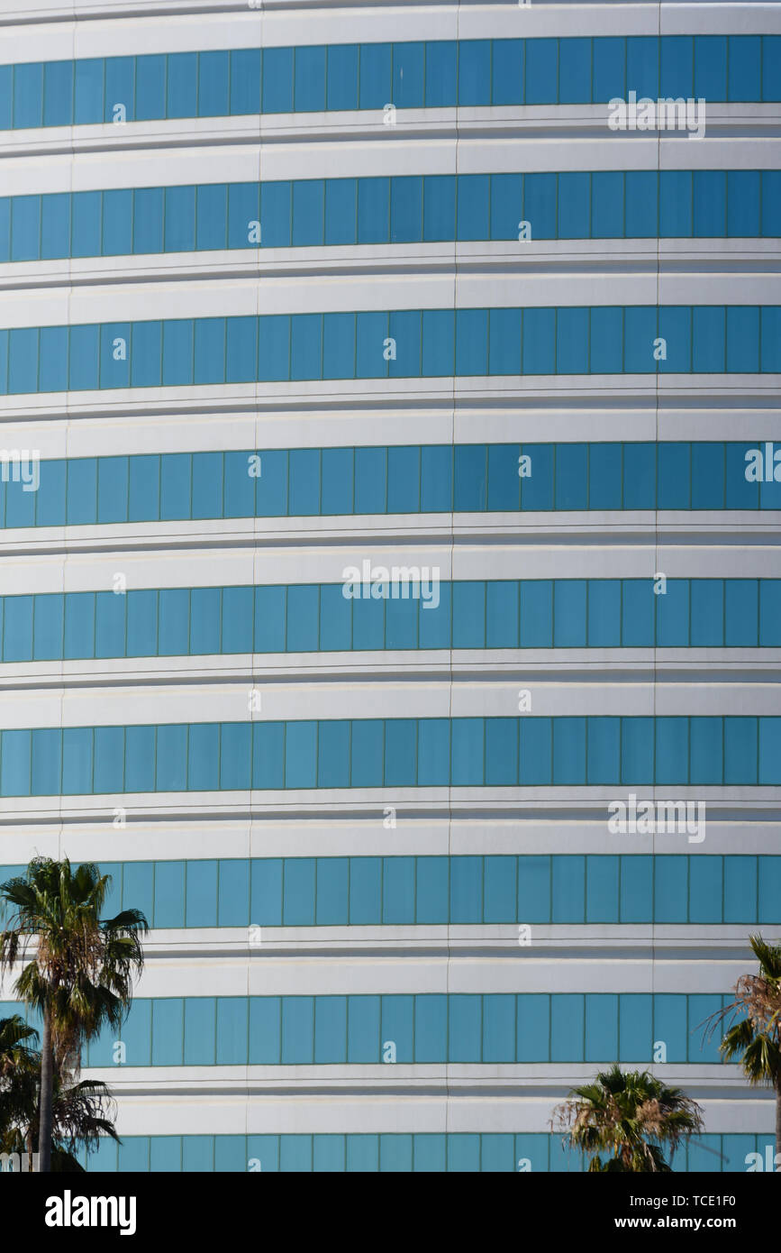 Tall building with blue stripes windows and white walls looking over ...