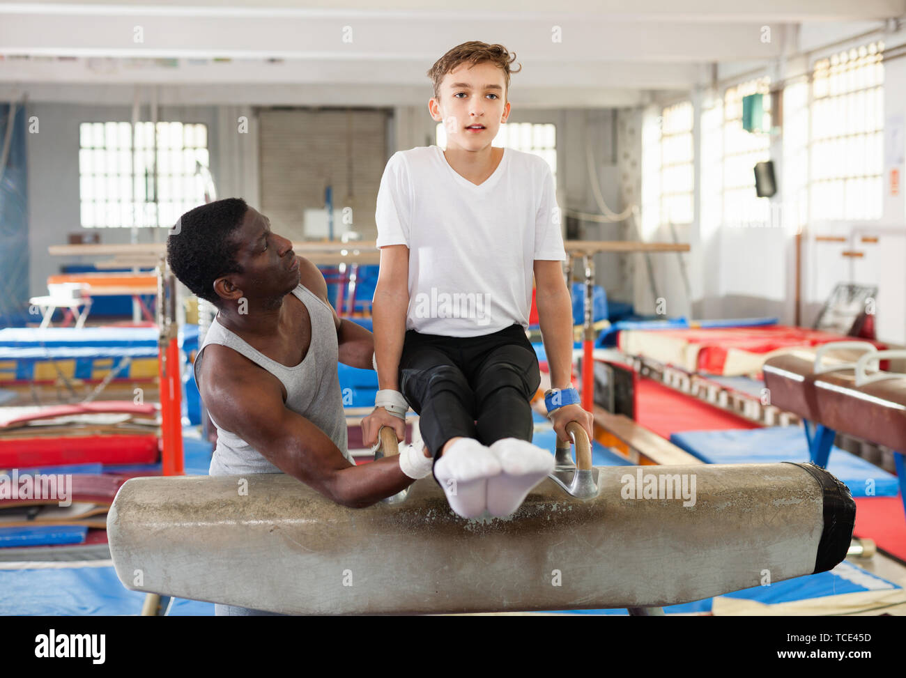 Efficient male coach training diligent positive teenage boy on ...