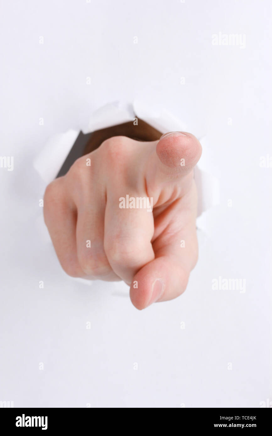 Pointing hand breaking through the paper Stock Photo - Alamy