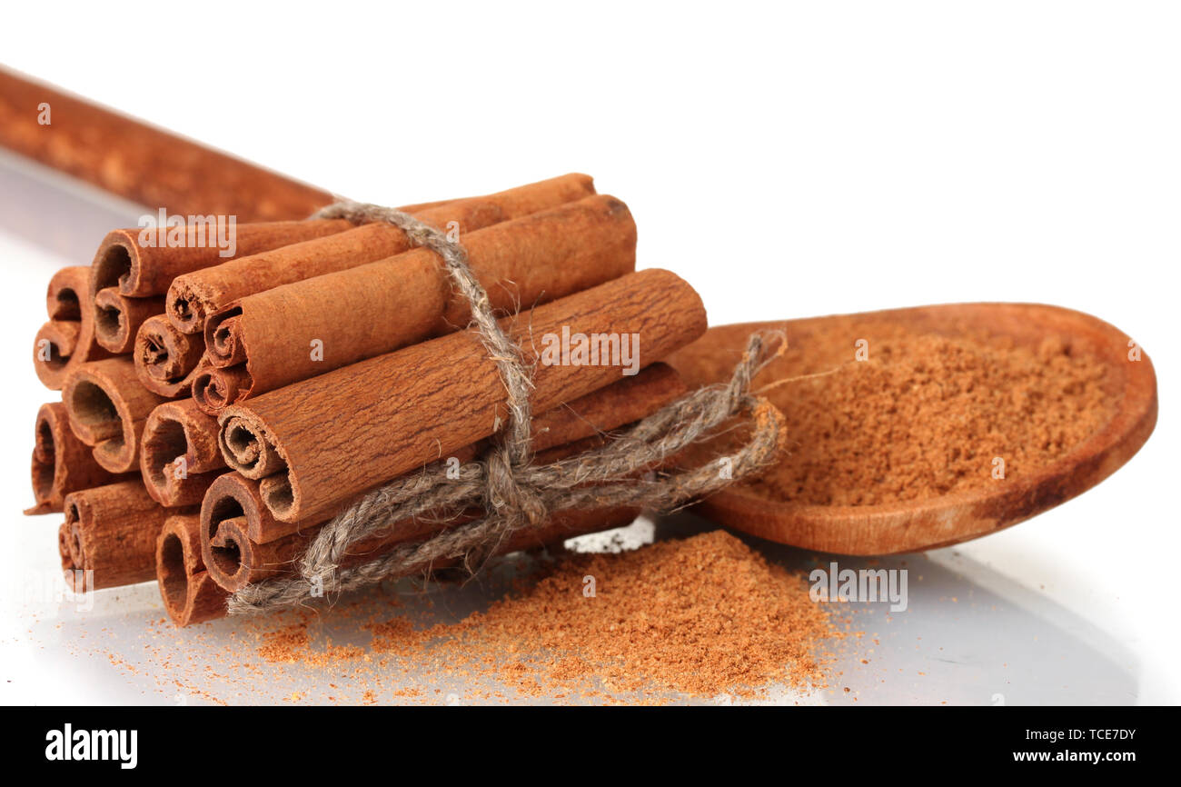 Cinnamon sticks and powder in wooden spoon isolated on white Stock ...