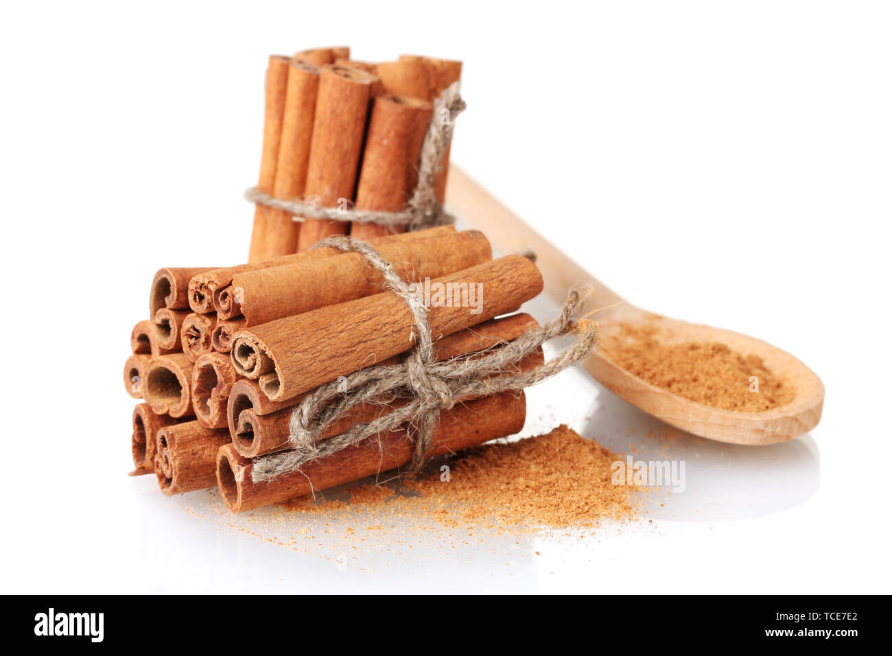 Cinnamon sticks and powder in wooden spoon isolated on white Stock ...