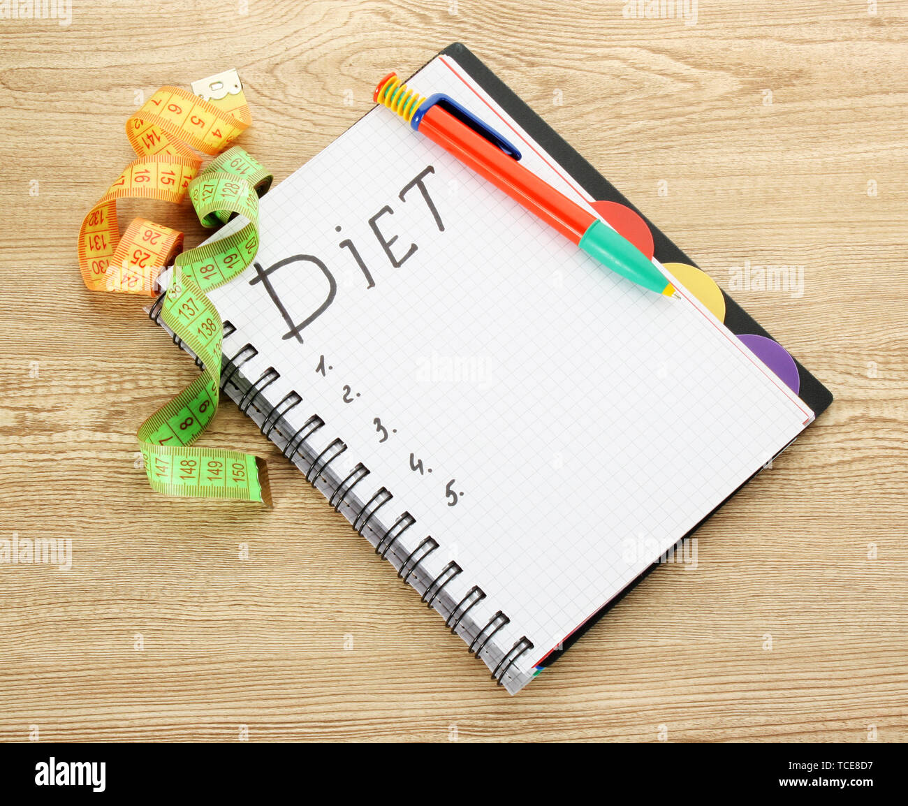 Planning of diet. Notebook measuring tapes and pen on wooden table ...