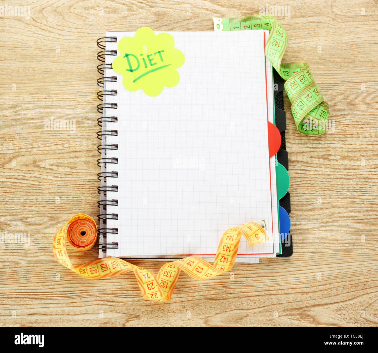 Planning of diet. Notebook measuring tapes and pen on wooden table ...