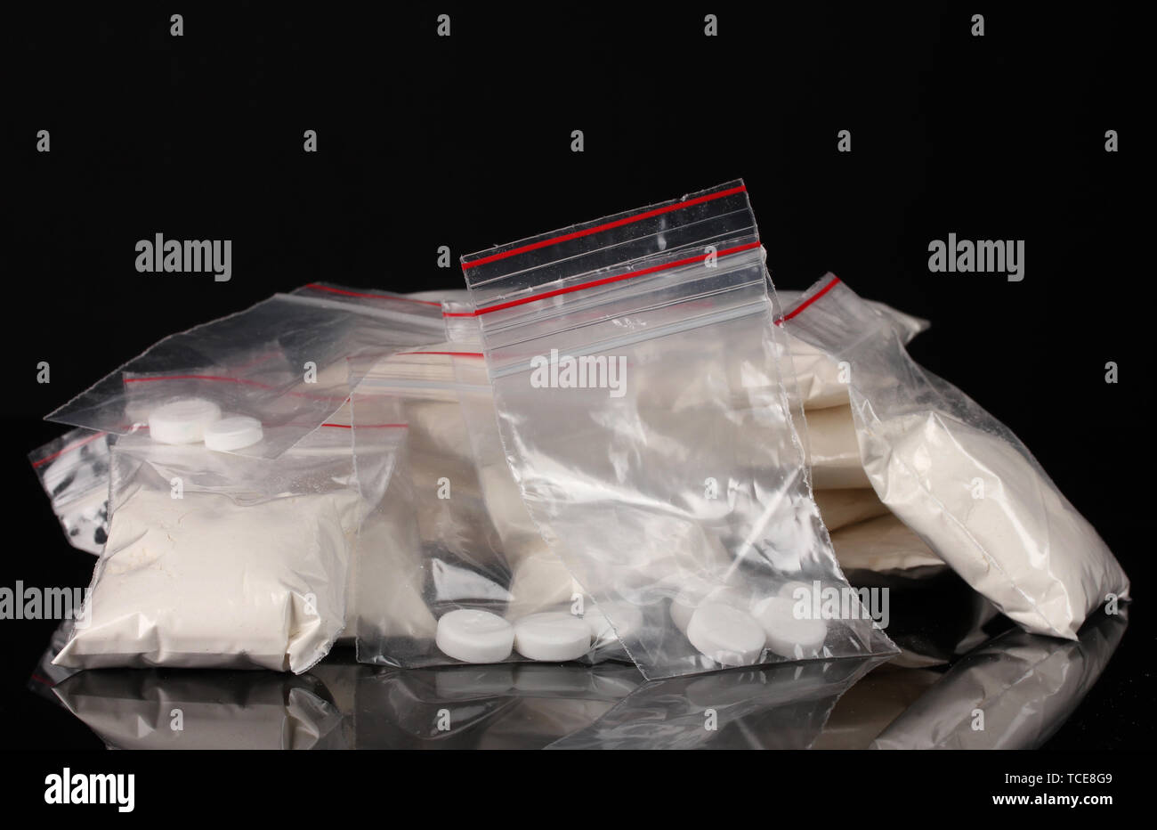 Cocaine and drugs in packages on black background Stock Photo - Alamy