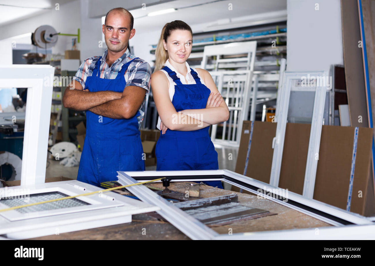 Portrait of two professional workers in assembly shop of plastic ...