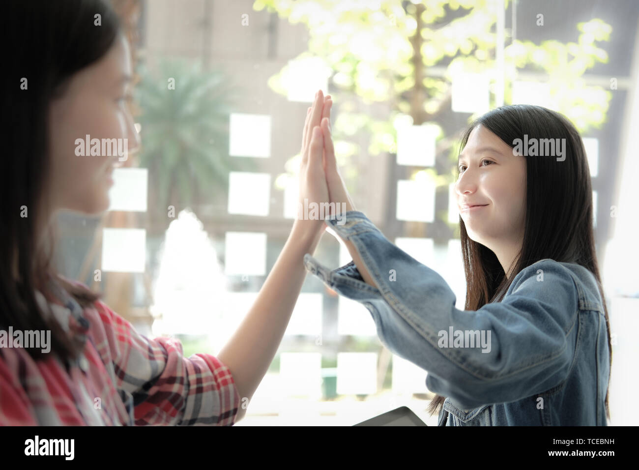girl teenager giving high five touching hands together. teamwork ...