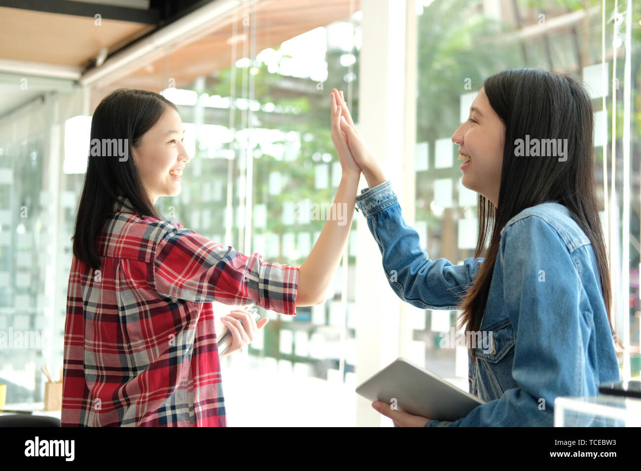 girl teenager giving high five touching hands together. teamwork ...