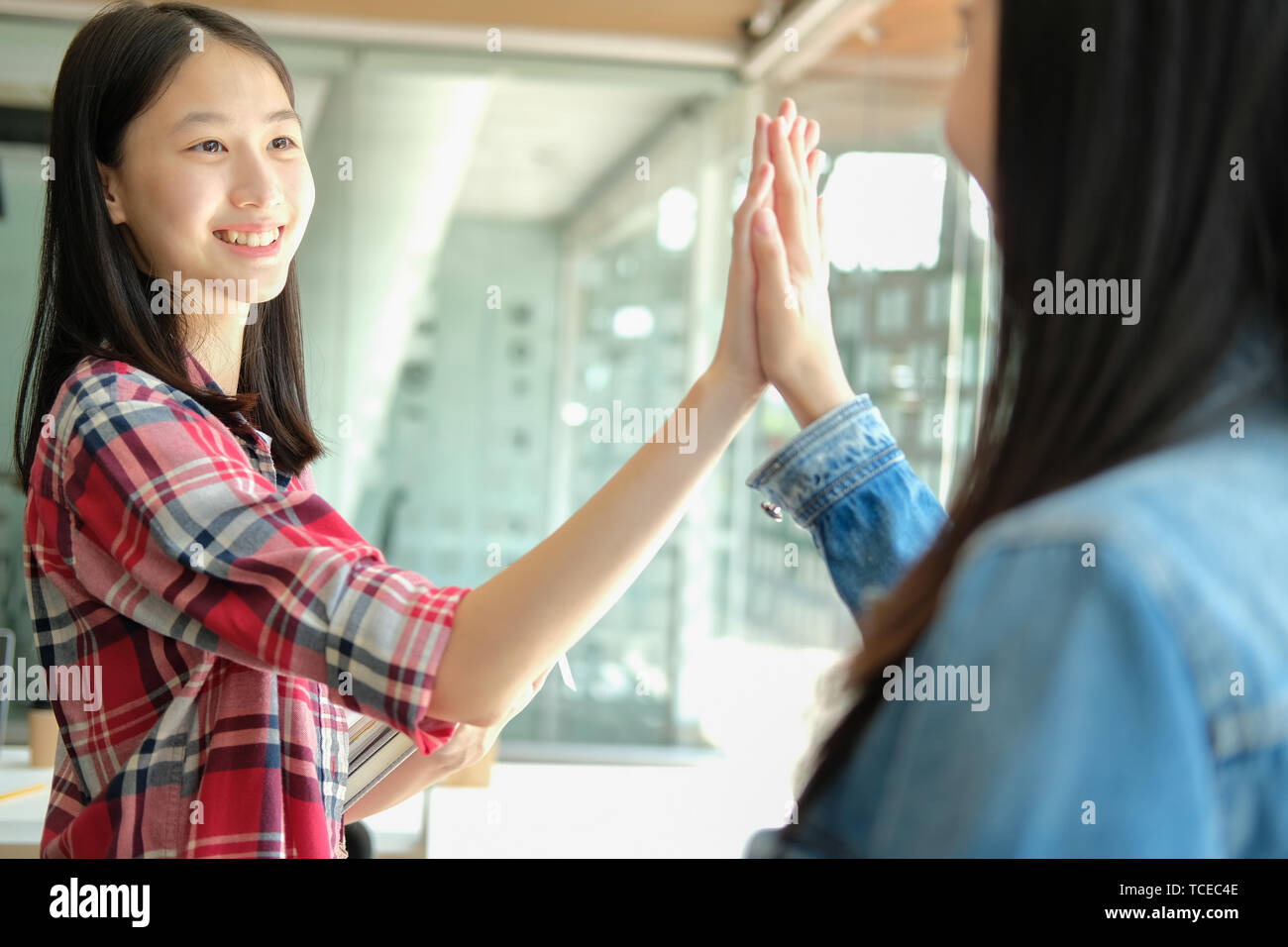 girl teenager giving high five touching hands together. teamwork ...