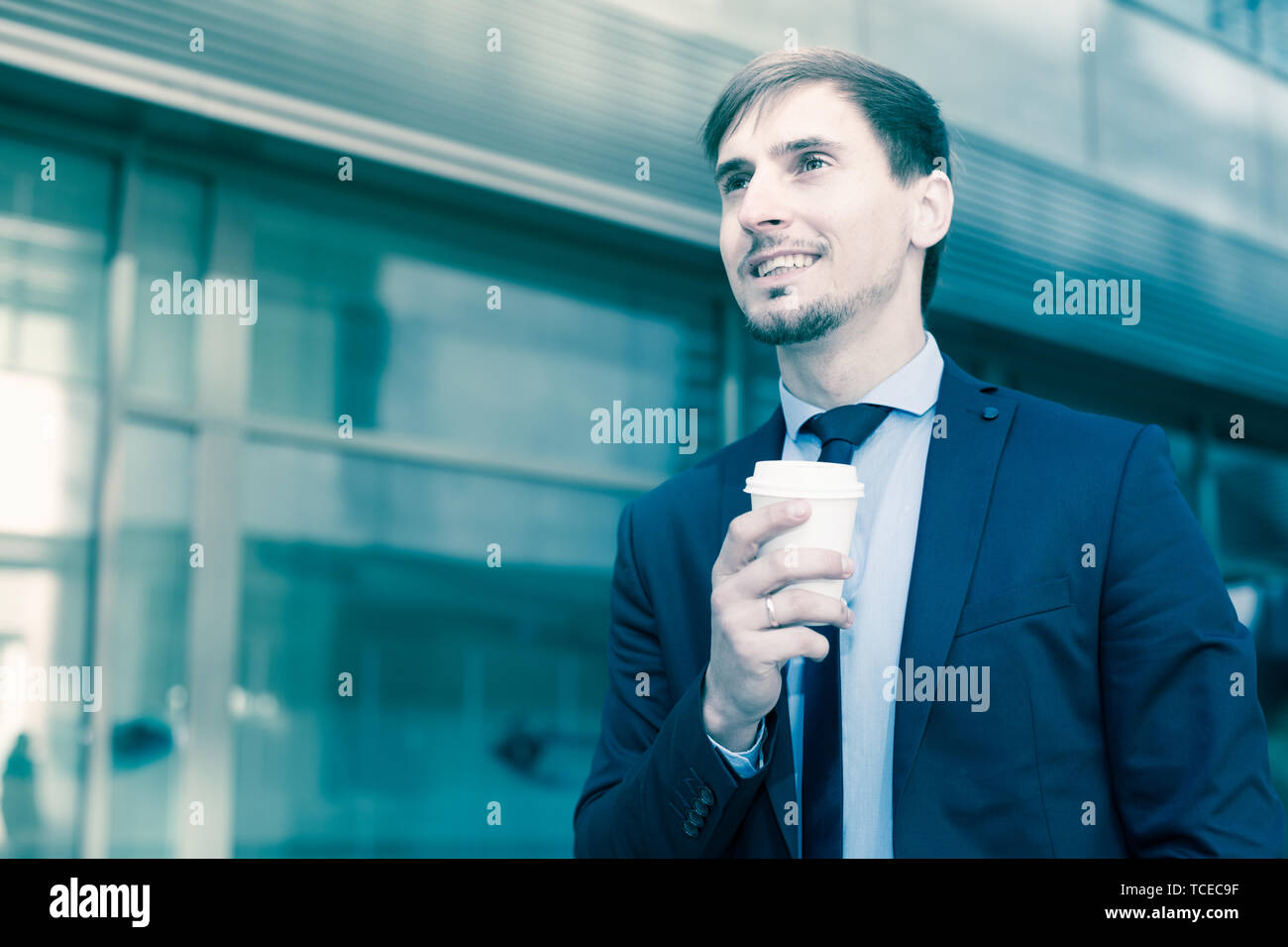 Portrait of cheerful male standing outdoor drinking coffee Stock Photo ...
