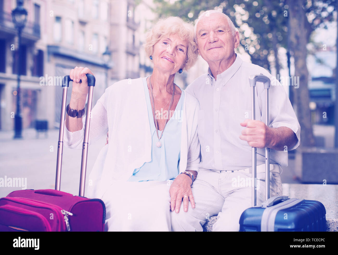 Happy loving aged spouses enjoying joint vacation sitting on bench ...