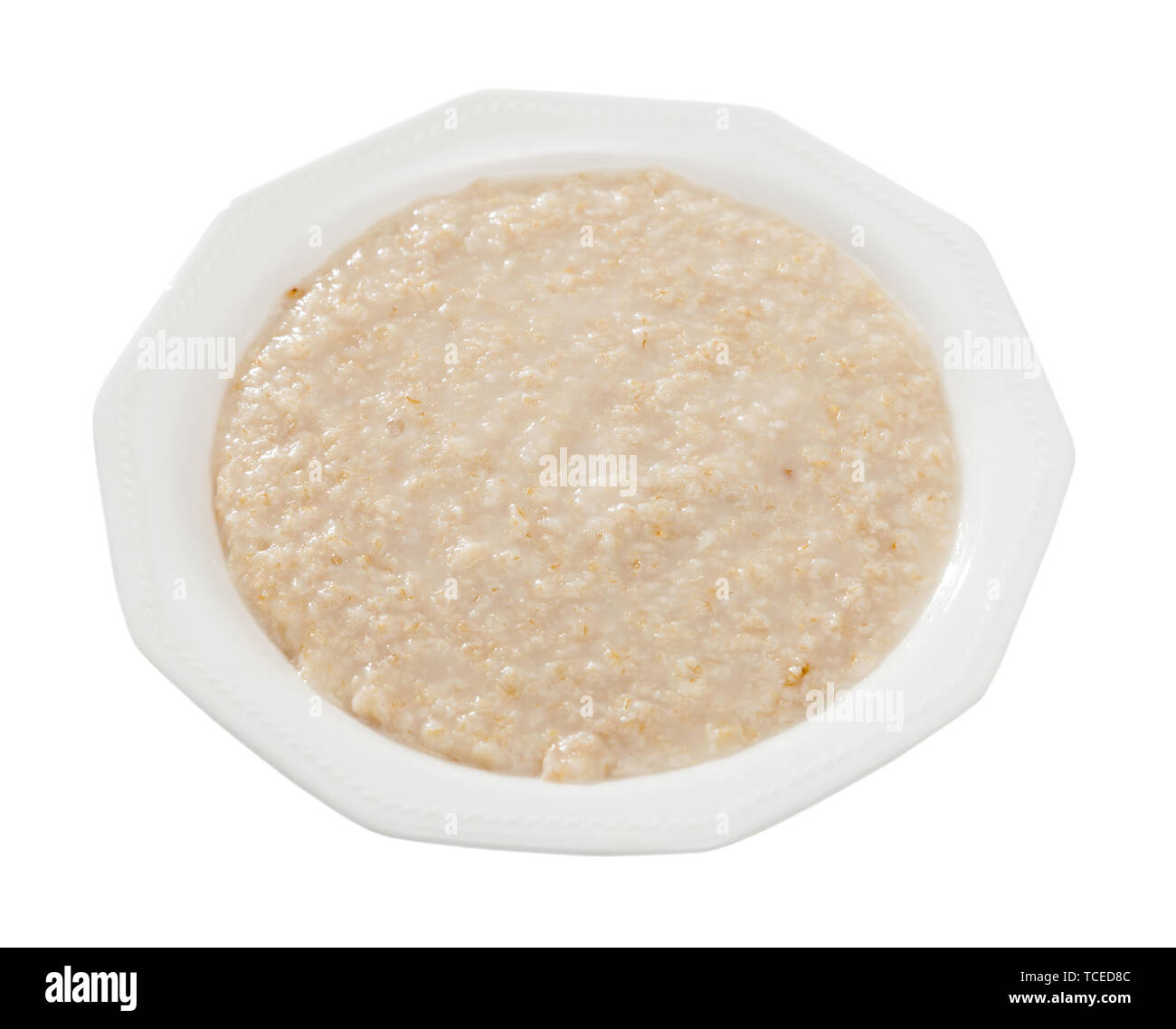 White plate with cooked oat porridge. Healthy diet breakfast. Isolated ...