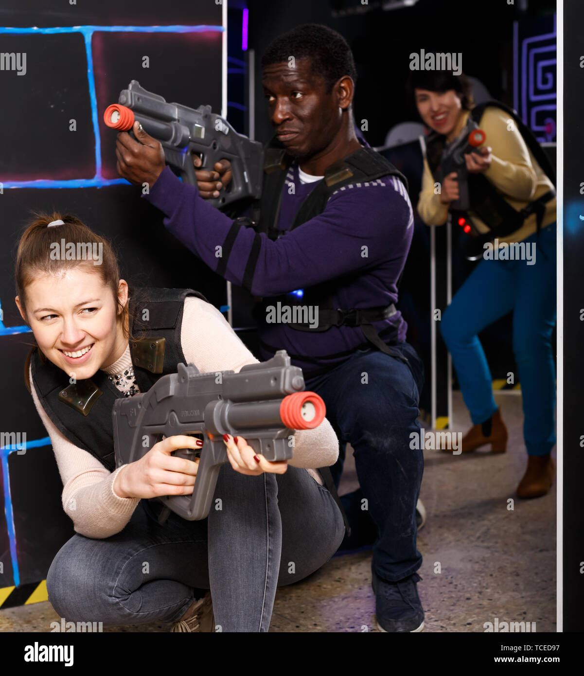 Two fine laser tag players of different nationalities aiming laser guns ...