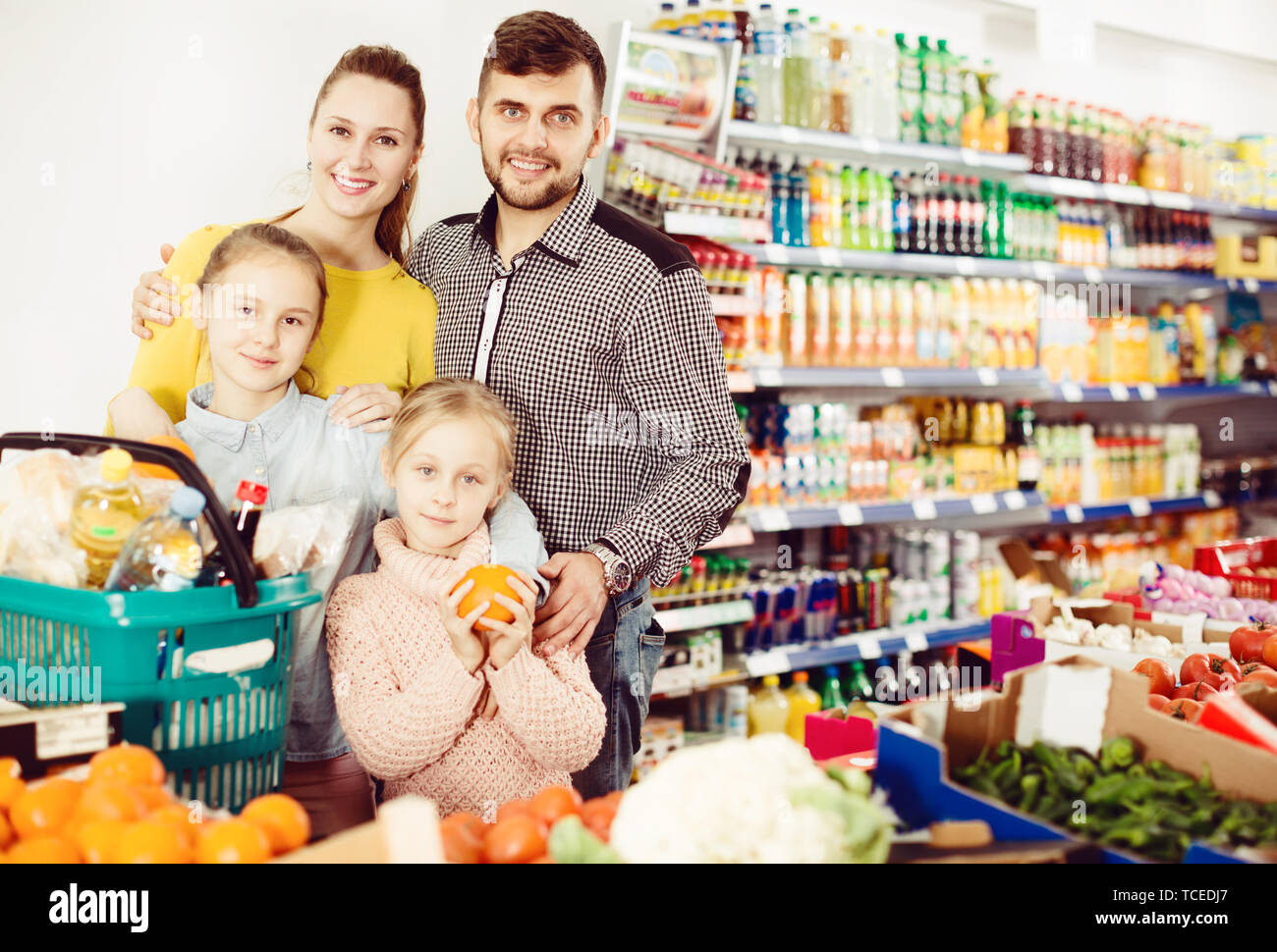 Cheerful Parents With Two Children During Family Shopping In Vegetable