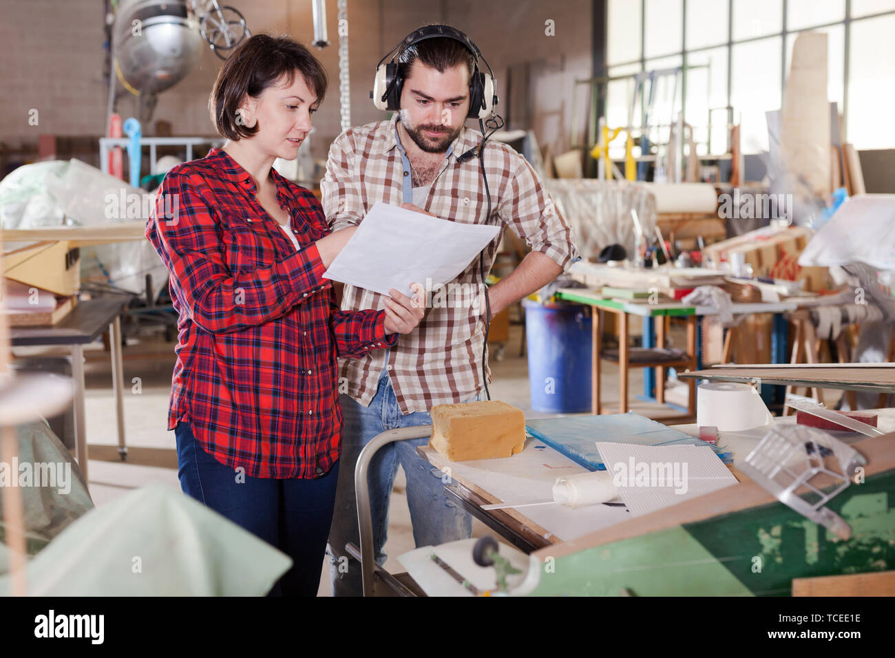 Female and male hobbyists engaged in creating plane models in aircraft ...