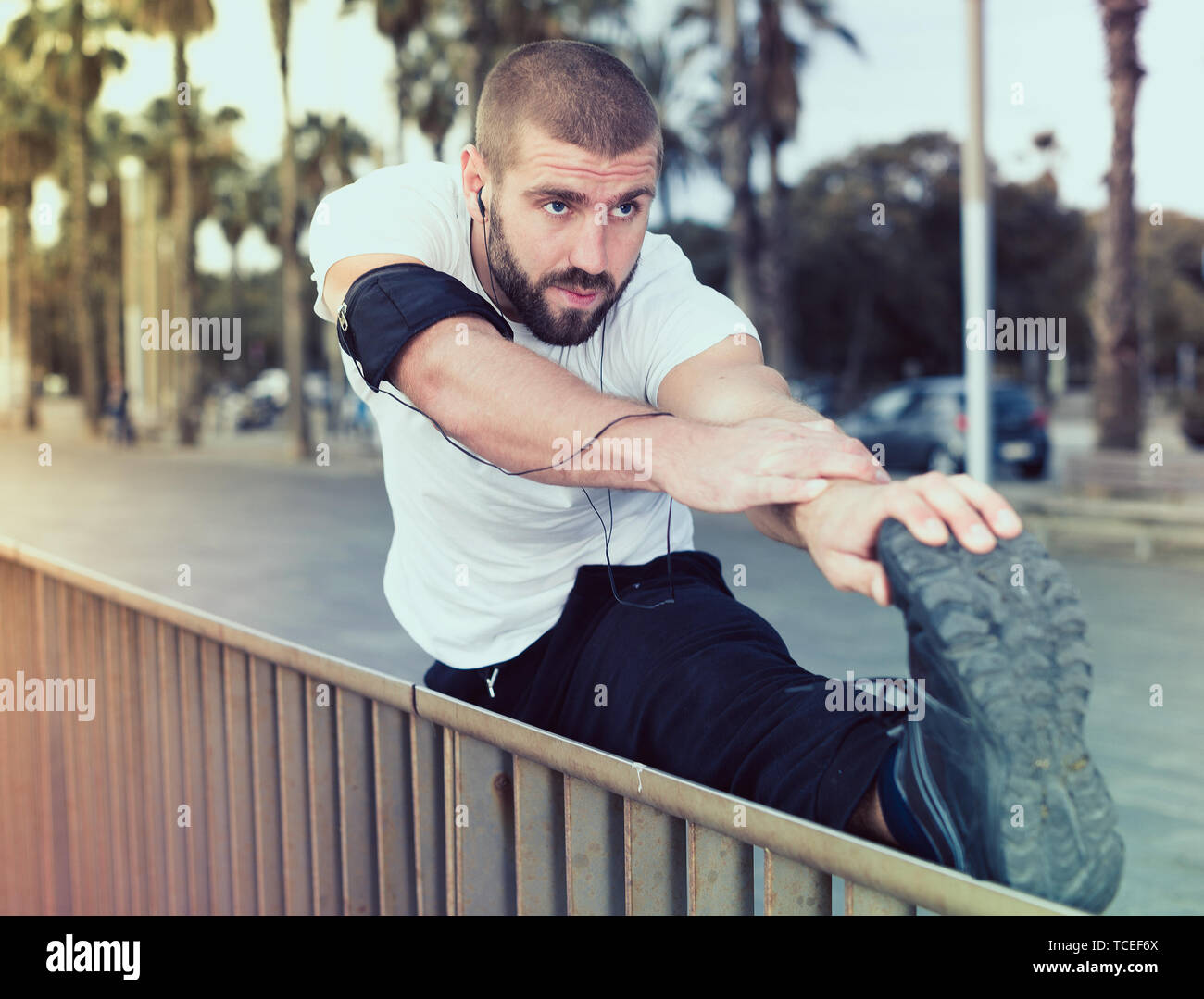 Young athletic man flexing his leg muscles before a long run Stock ...