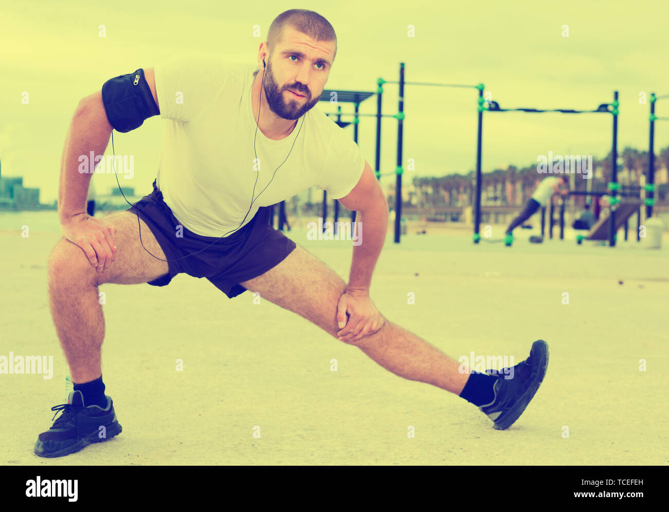 Athletic male performs warm-up exercises before training Stock Photo ...
