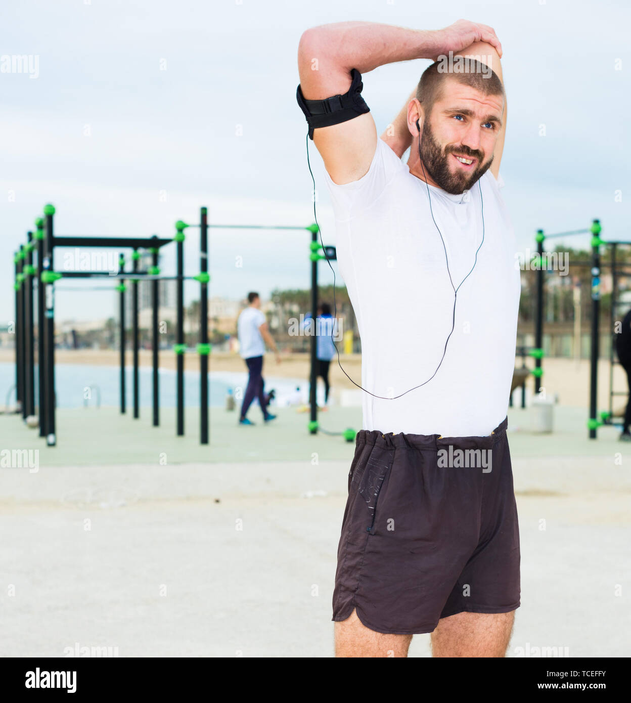 Athletic male performs warm-up exercises before training Stock Photo ...