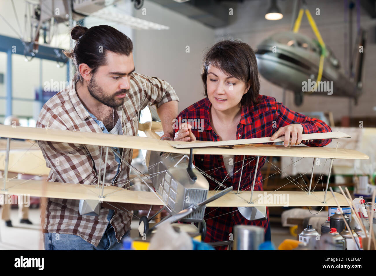 Portrait of nice female and male hobbyists with plane models created by ...