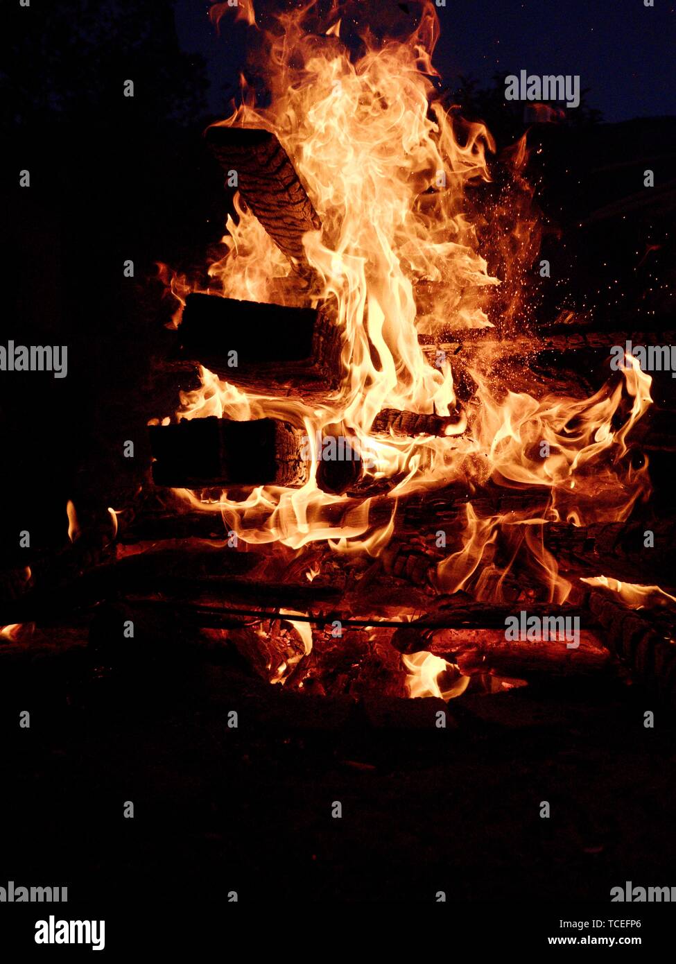High flames from big bonfire on festival at the nigtht, long trunk ...