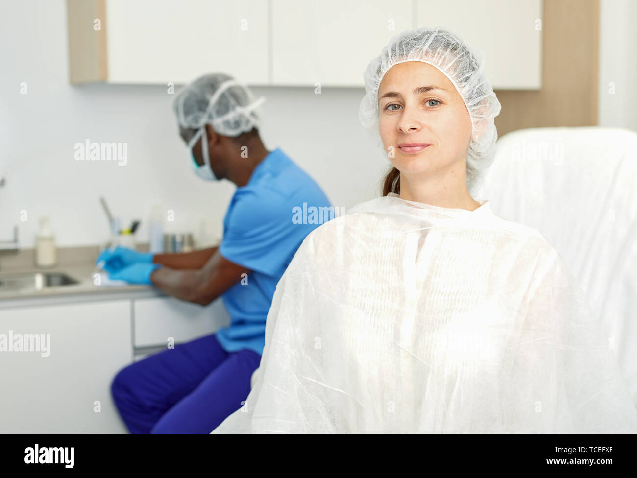 Female client in armchair before facial procedure in clinic of esthetic ...